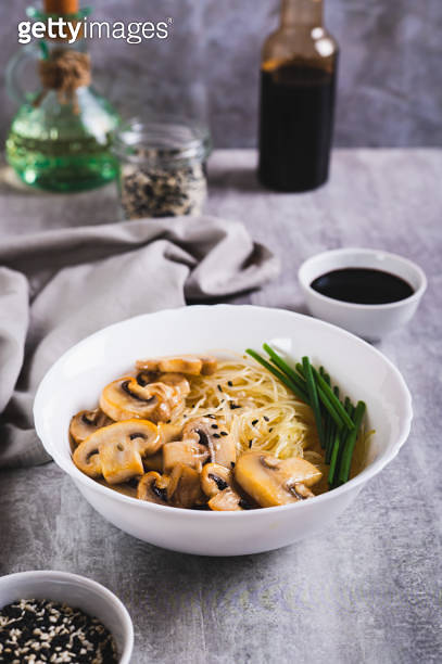Funchose rice noodles with mushrooms and green onions in a bowl on the ...
