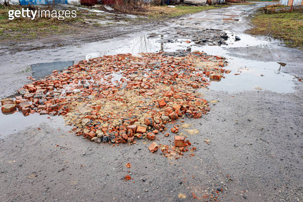 Damaged road in the countryside. Potholes in the road sealed with old ...