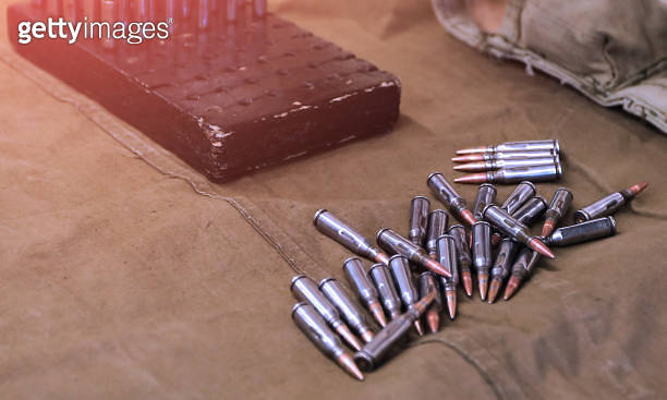 Soldiers Hand Holding Bullet from Wooden Box with Scattered Bullets on ...