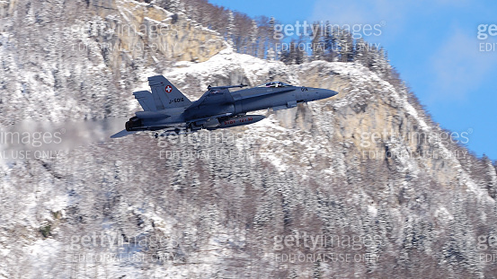 Armed Fighter Jet Takes Off on Sunny Winter Day with Snowy Mountains ...