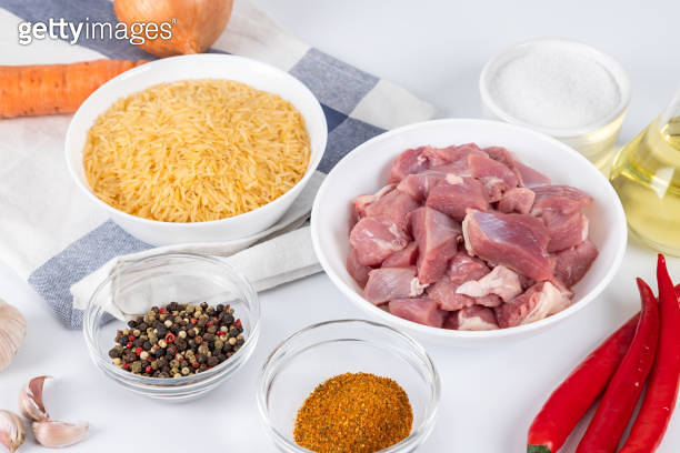 Prepared raw ingredients for cooking pilaf in modern multi cooker in ...