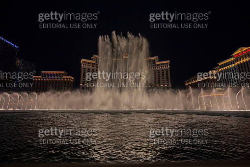 Beautiful view of the Bellagio Fountains at night, with water jets illuminated against the ...