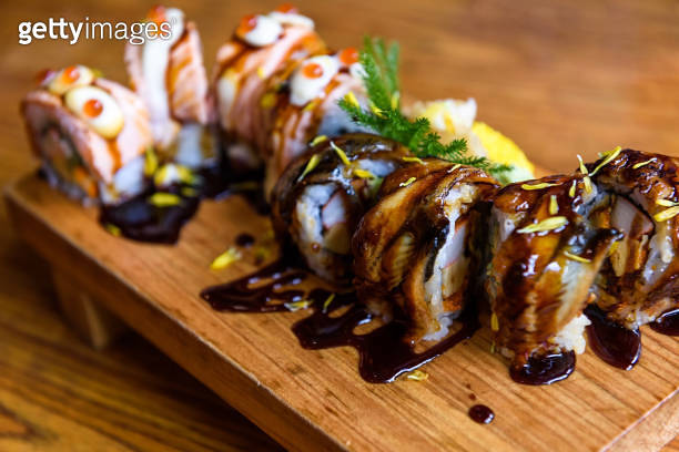 eel and salmon sushi nigiri rolls on wooden dish in Japanese restauran ...