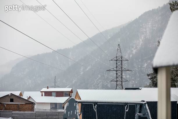 nature and technology, this photo shows a snowy village with power ...