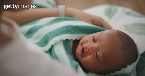 Young asian mother holding newborn in arms Rocking for baby to sleep ...