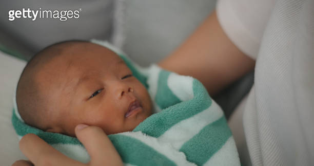 Young asian mother holding newborn in arms Rocking for baby to sleep ...