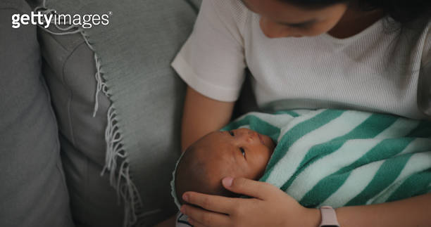 Young asian mother holding newborn in arms Rocking for baby to sleep ...