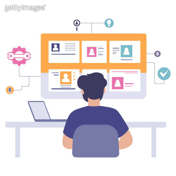 Back view of a man analyzing multiple user profiles on a computer ...