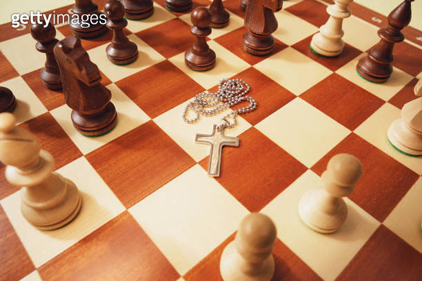 Catholic religious cross with chess pieces of kings on a chessboard ...