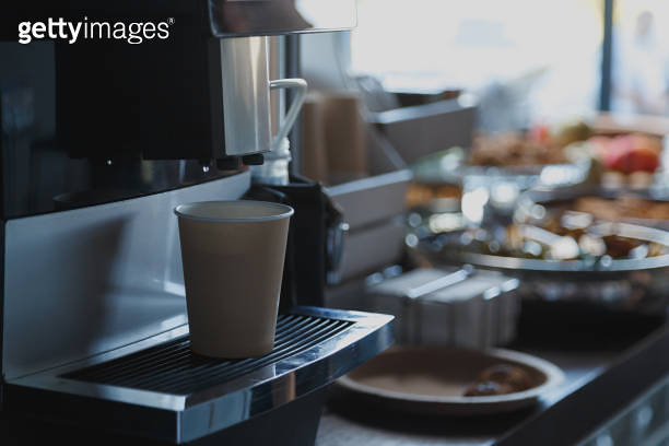 Coffee machine prepares coffee in a cup for takeaway, at a buffet ...