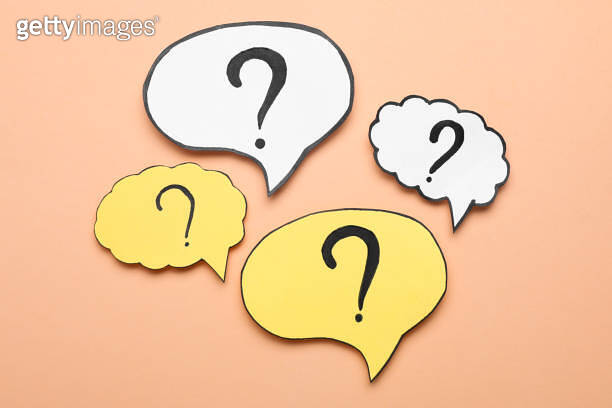 Paper speech bubbles with question marks on beige background, flat lay ...