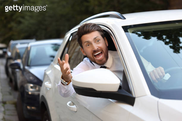 Angry driver screaming at someone from car in traffic jam (1932635992 ...