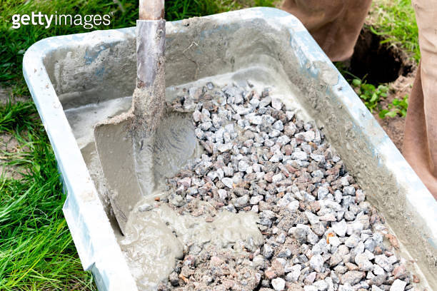 worker man mixing, stirring cement slurry, concrete rubble mortar with ...