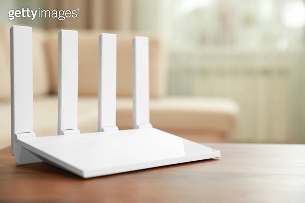 New modern Wi-Fi router on wooden table indoors. Space for text 이미지 (1911045821) - 게티이미지뱅크