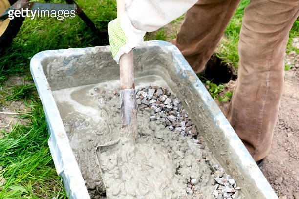 worker man mixing, stirring cement slurry, concrete rubble mortar with ...