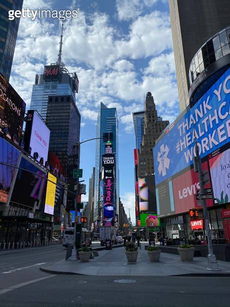 Times Square intersection no people, sidewalk in shadow under blue sky ...