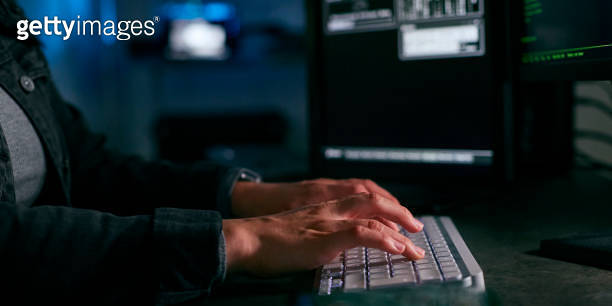 Close Up On Hands Of Female Computer Hacker Sitting In Front Of Screens ...