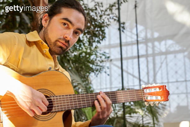 Young man playing guitar sitting green grass outdoor picnic nature guy ...