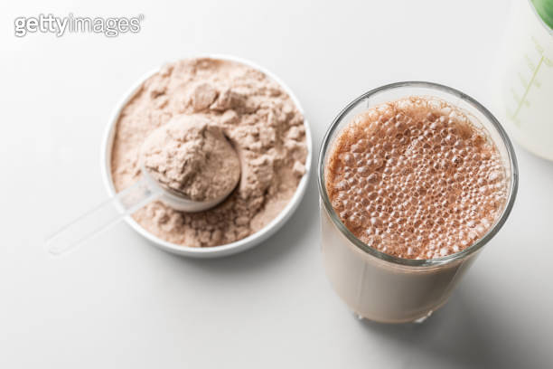 Protein drink cocktail in a glass and whey protein powder in a ...