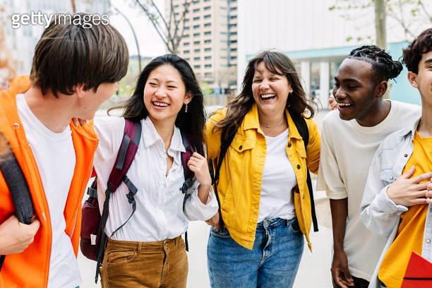 Multiracial group of happy students laughing and having fun together at ...
