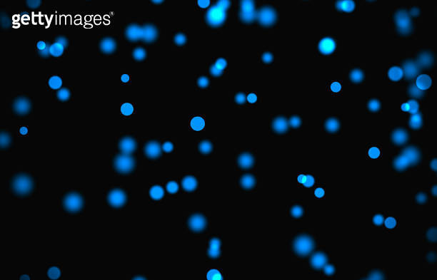 dreamy array of glistening blue bokeh lights sparkle on black ...