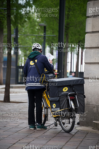 portrait of post man standing near his bicycle in the street 이미지 ...