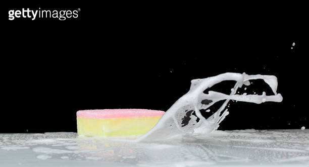 Hand in orange rubber glove hold cleaning brush sponge and wipe soap ...