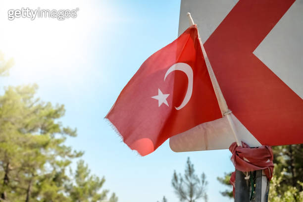 Waving Turkish flag tied to a road sign post. Independence and freedom ...