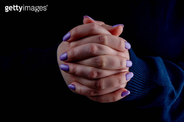 Folded fingers of a young woman with a fashionable stylish lilac ...