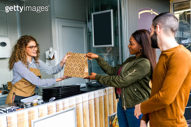 Female worker giving orders to customers in a fast food restaurant 이미지 ...
