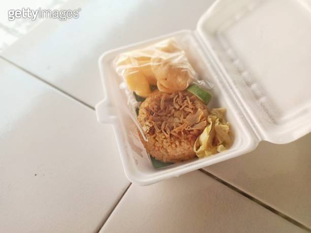 spicy fried rice and crackers served in a styrofoam container ...