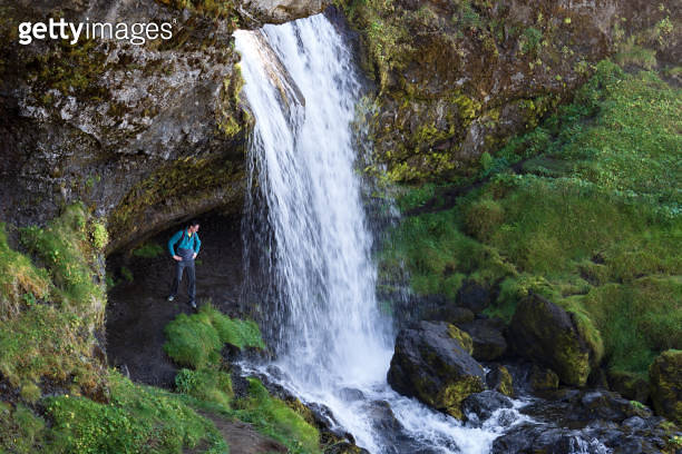 Adult man standing behind Selvallafoss - the Sheep’s Waterfall in ...