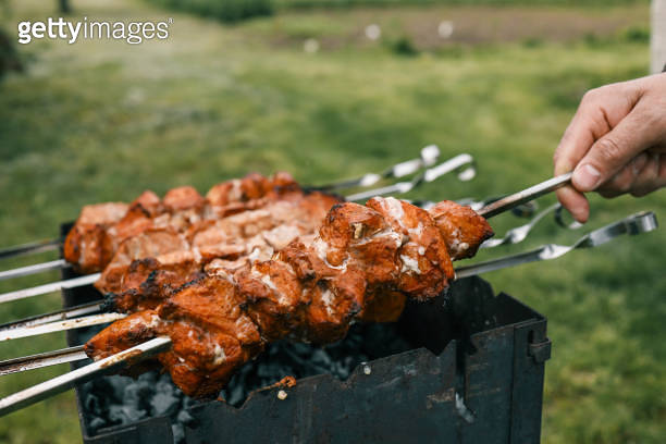 Man hand grilling barbecue with smoked pork at backyard on day. Family ...