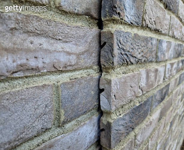 suspended brick-shaped tiles are anchored to the metal structure in a ...