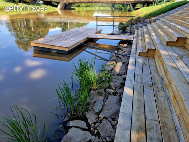 a floating jetty for mooring ships is fixed with metal rods on hinges ...