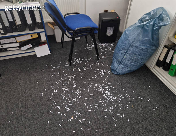document shredding at workplace in office. he cuts the papers into ...