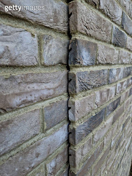 suspended brick-shaped tiles are anchored to the metal structure in a ...