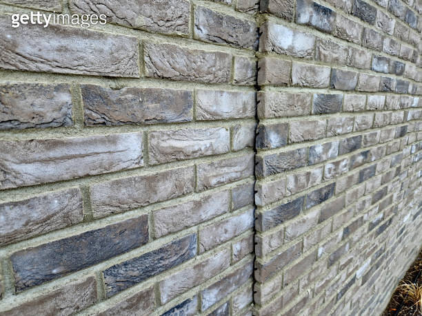 suspended brick-shaped tiles are anchored to the metal structure in a ...