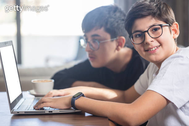Two boys working together on a laptop computer (1800440777) - 게티이미지뱅크