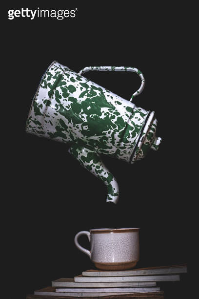 still life photography of enamel teapot and cups on a stack of books ...
