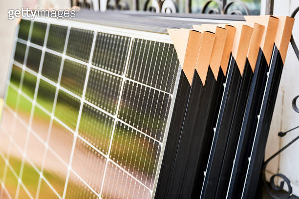Close-up new solar panels with protective cardboard corners ready for ...