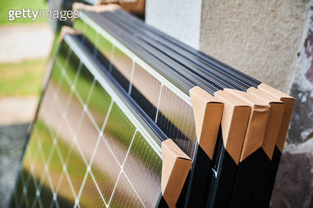 Close-up new solar panels with protective cardboard corners ready for ...