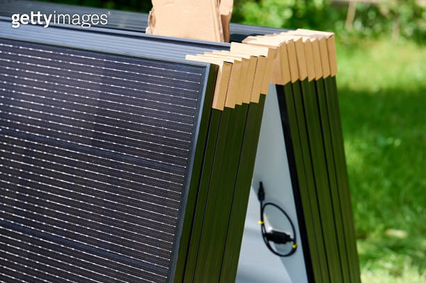 Close-up new solar panels with protective cardboard corners ready for ...