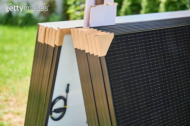 Close-up new solar panels with protective cardboard corners ready for ...
