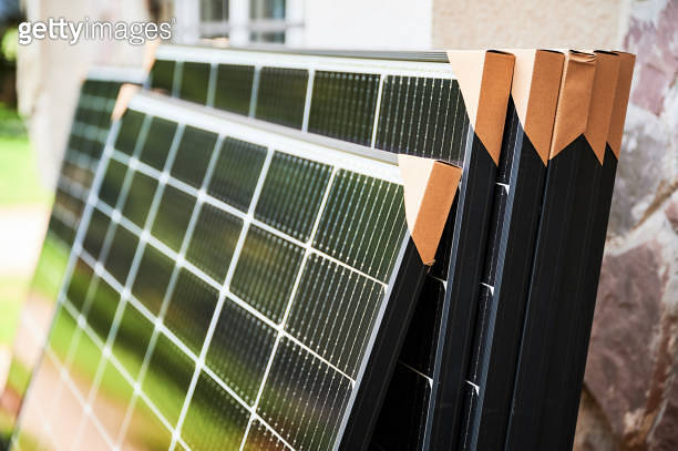 Close-up new solar panels with protective cardboard corners ready for ...