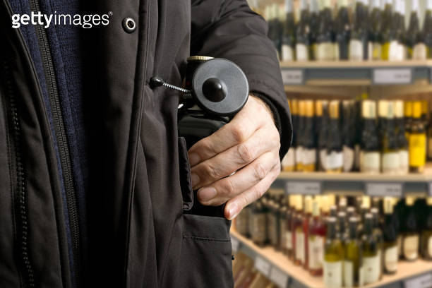 theft incident as a shoplifter attempts to steal a bottle of alcohol ...