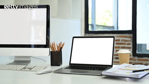 Blank computer monitor, laptop and financial document on white table in ...