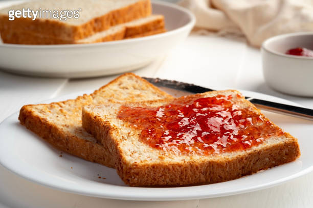 Close up Toast bread and Strawberry Jam.Spreading jam on slice whole ...