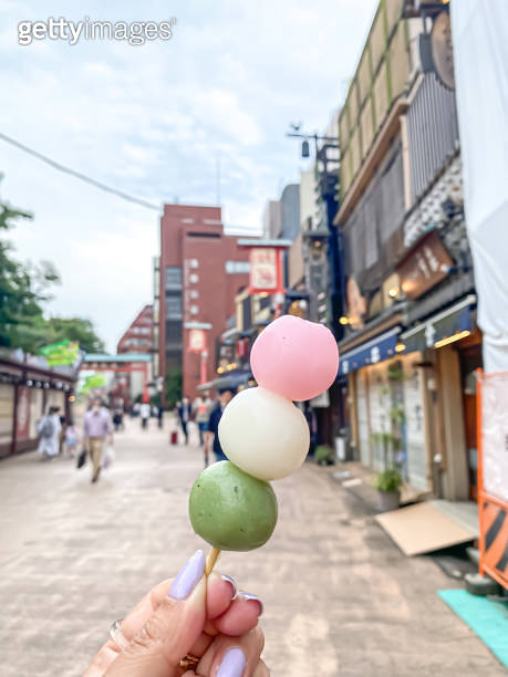 Someone hand holding tasty fancy Dango, a Japanese dumpling made from ...