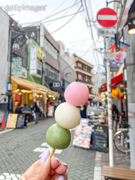 Someone hand holding tasty fancy Dango, a Japanese dumpling made from ...